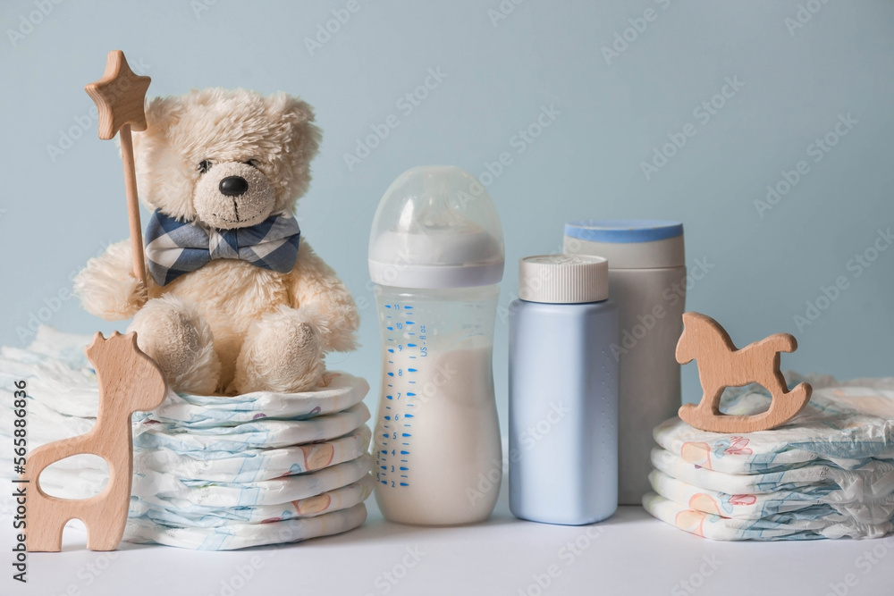 Wooden toys, a bear in a bow tie, a stack of diapers, bottles without ...