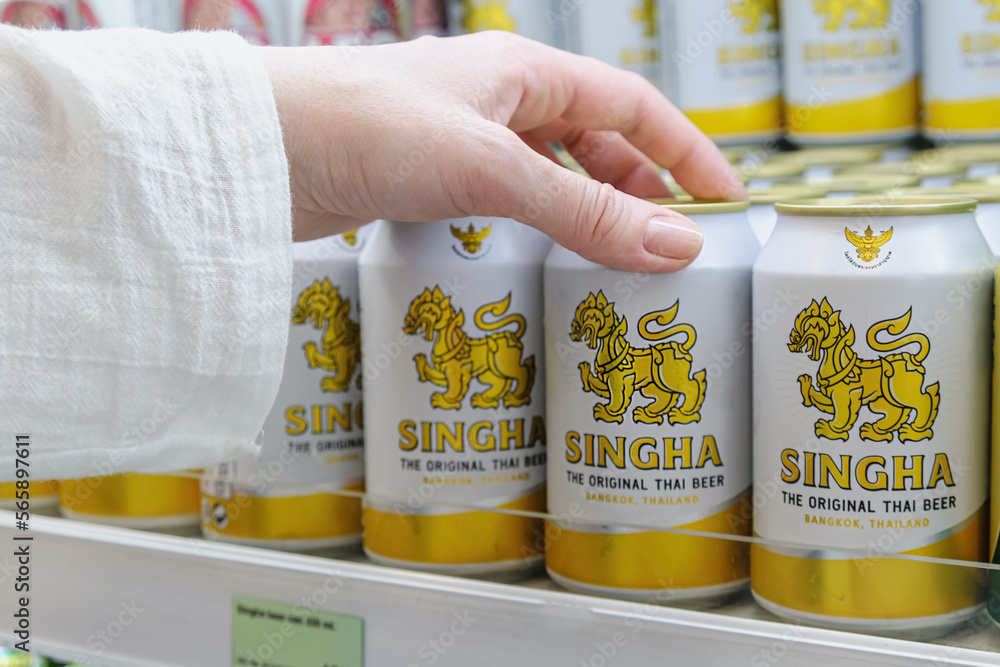 Man picks up a can of popular Thai beer Singha from a supermarket shelf ...