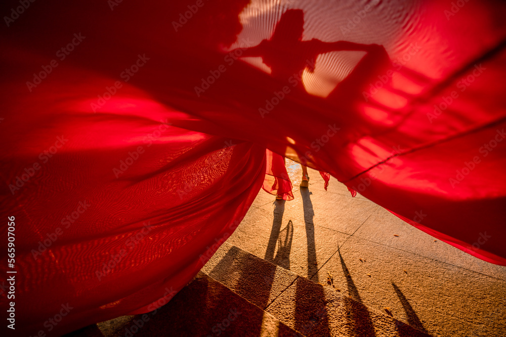 Sunrise red dress. A woman in a long red dress against the backdrop of ...