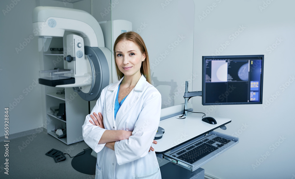 Experienced female radiologist standing near mammography workstation at ...