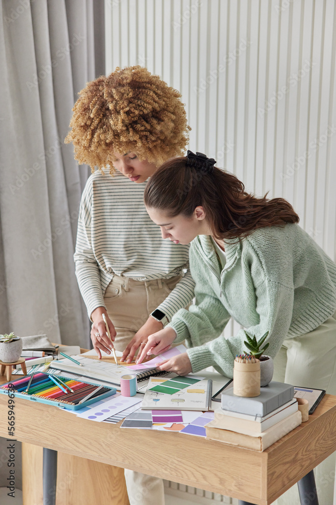 Two female designers work together as team draw interior design for ...