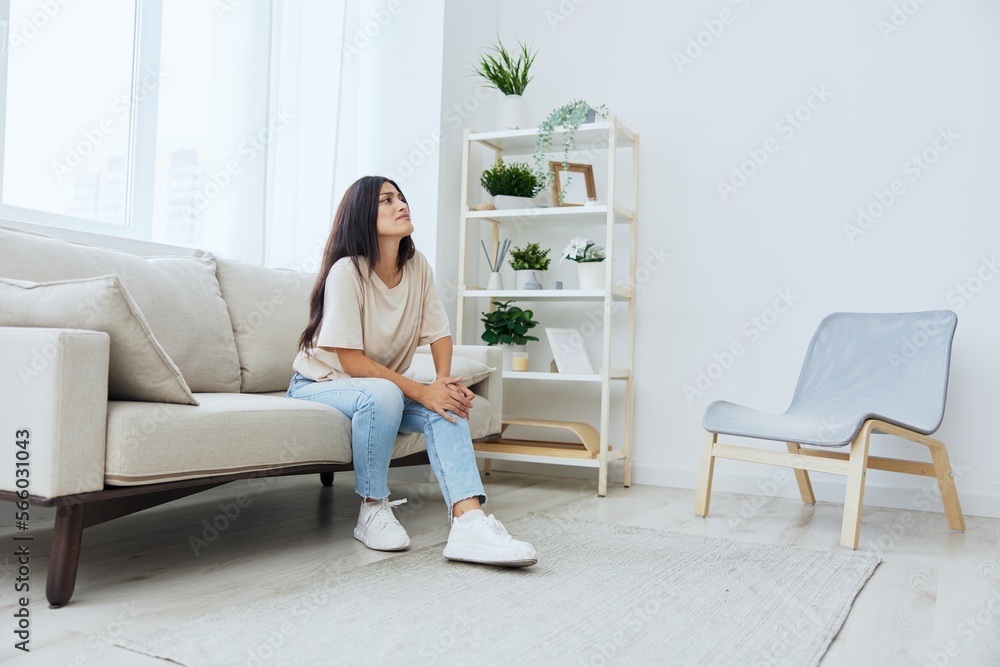 Woman sitting on the couch at home leg and foot pain, sprain and muscle ...