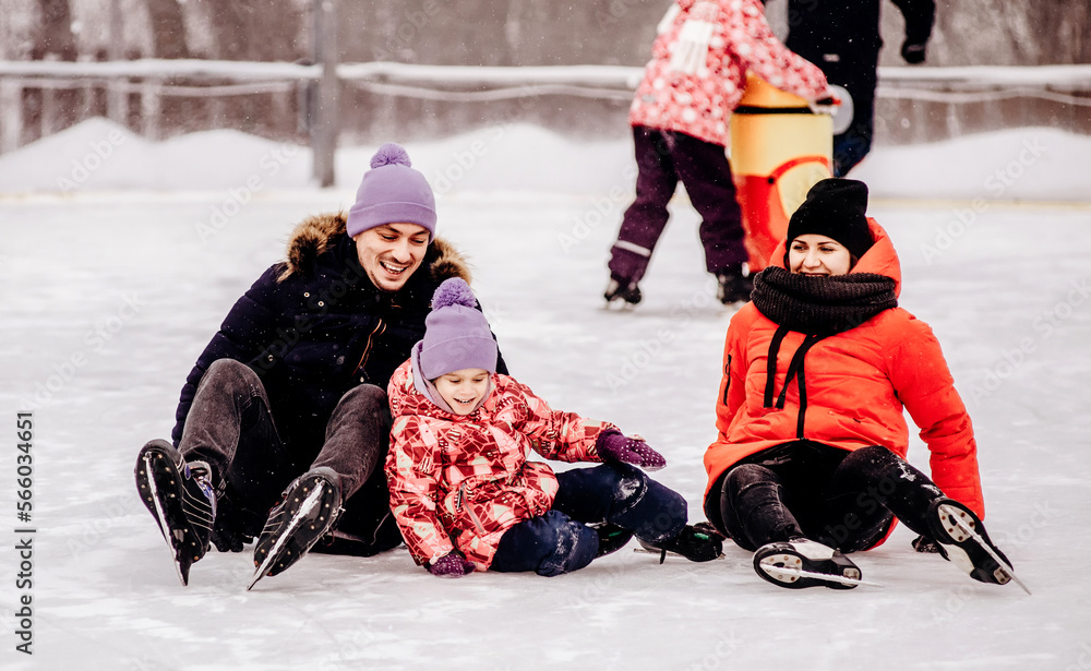 Happy family spending time together at outdoor ice skating rink ...