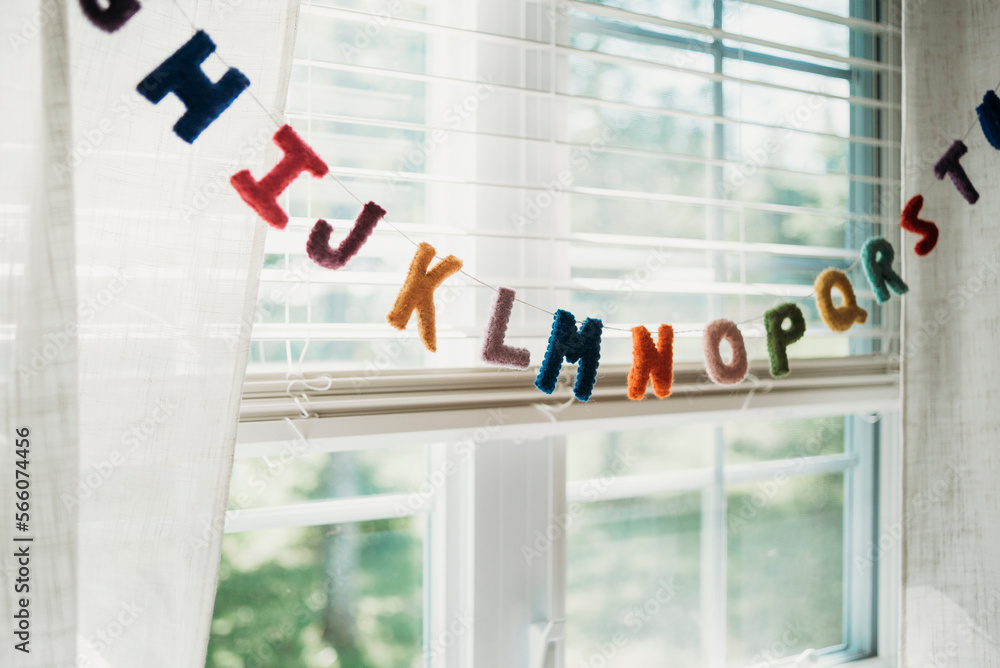 Multi colored alphabet decoration hanging on string by window at home ...