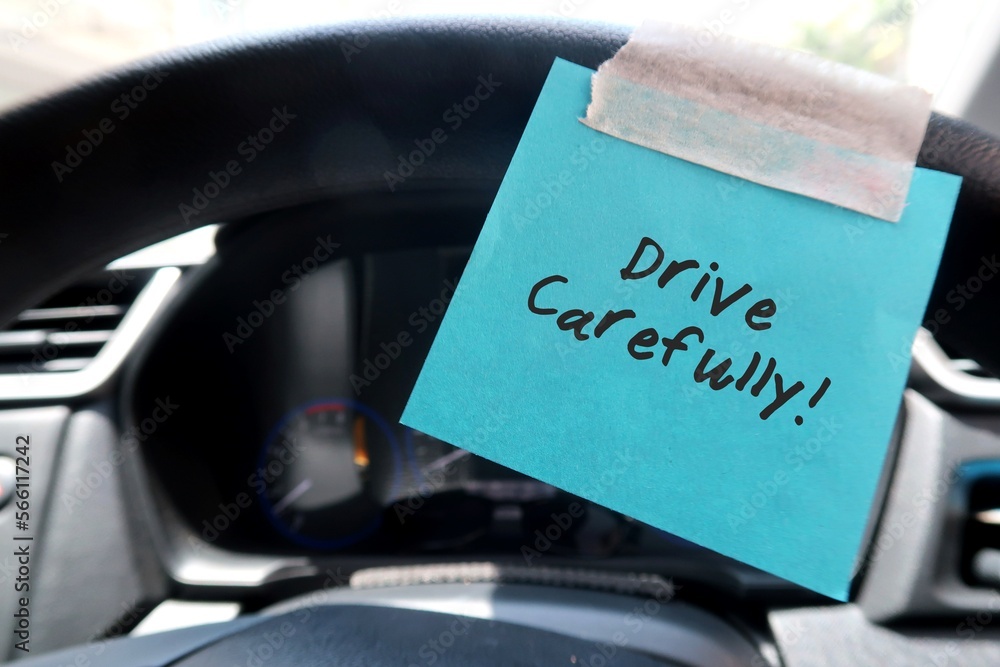 A blue paper note sticking on the car steering wheel, with text written ...