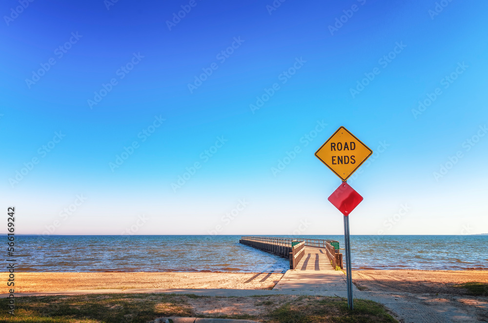 Road sign with Road Ends text in front of pier, Lake Huron, Michigan ...