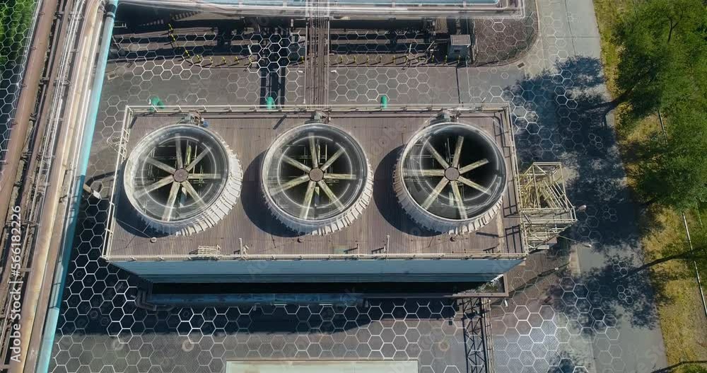 A futuristic shot of a factory exterior. Industrial cooling towers with ...