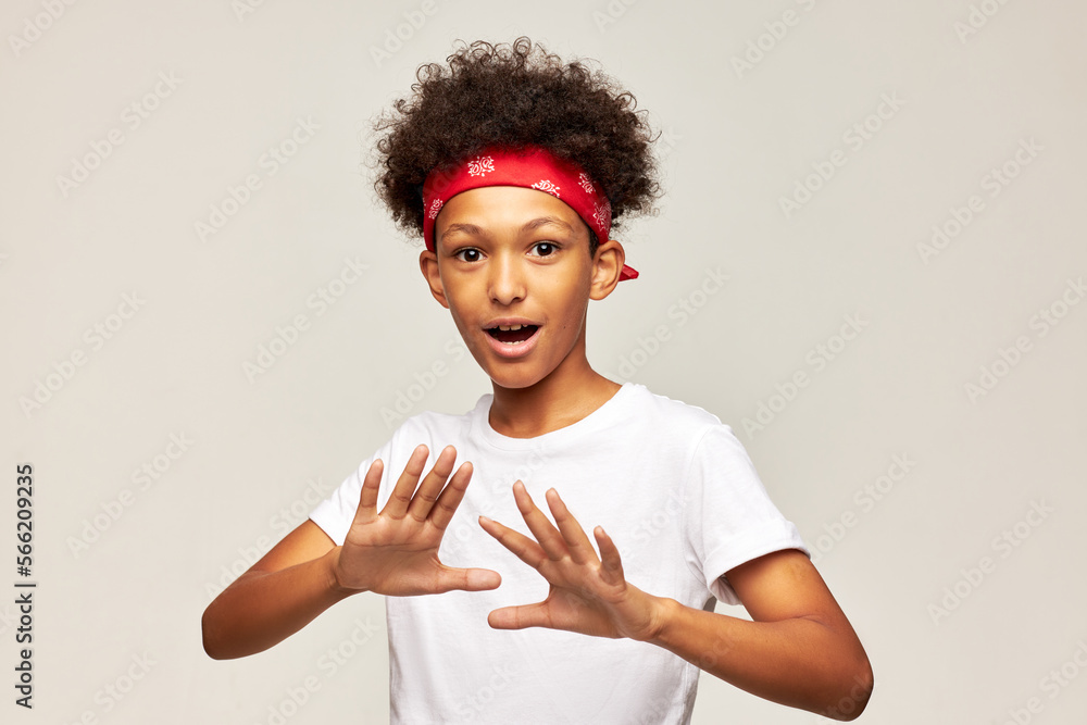 Portrait of funny afro kid boy doing no or stop gesture with palms ...