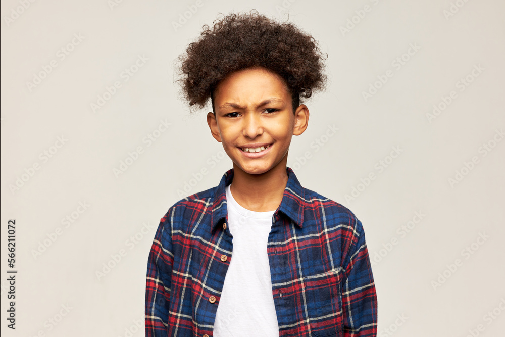 Grumpy dissatisfied black teenage boy in plaid flannel shirt frowning ...