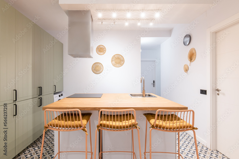 Big kitchen island is surrounded by tall bar stools with soft yellow ...