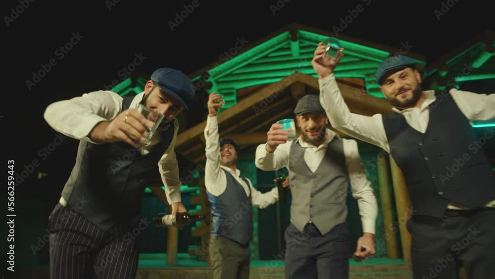 Group of young drunk men drinking alcohol , toasting , cheering ...