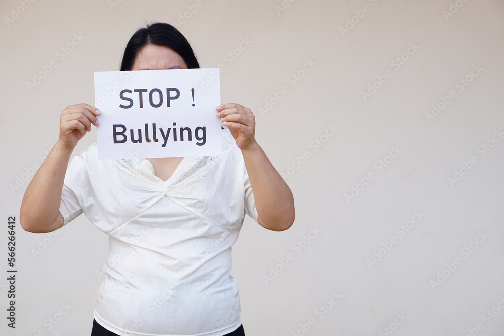 Closeup woman holds paper with text " STOP! Bullying" Concept, campaign for anti bullying, body ...
