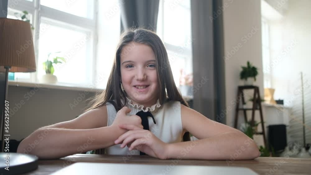 Funny little girl smiling looking at camera at home, cute kid talking ...