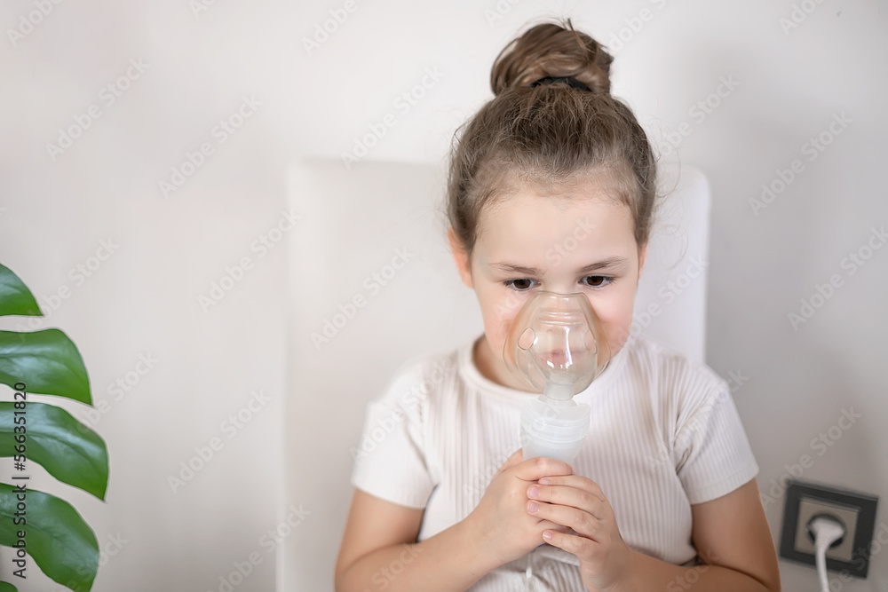 a little girl is doing an inhalation. Treatment of asthma, cough. the ...