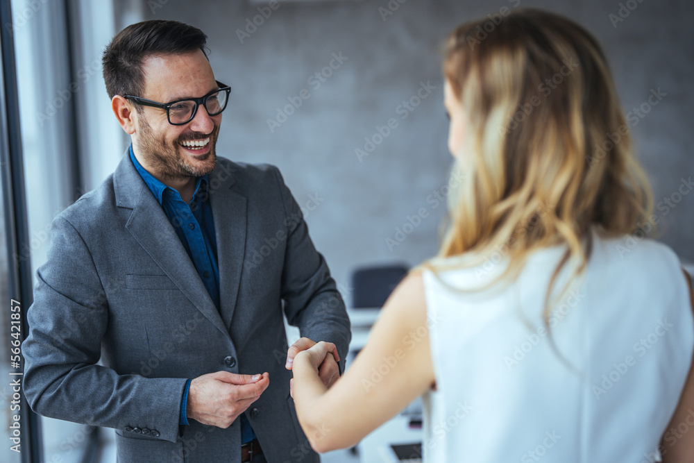 Shot of two businesspeople shaking hands in an office. Smiling business ...