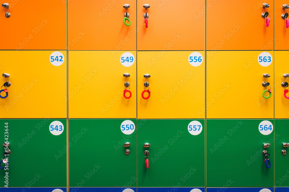 Orange, yellow and green lockers with keys and numbers in a public ...