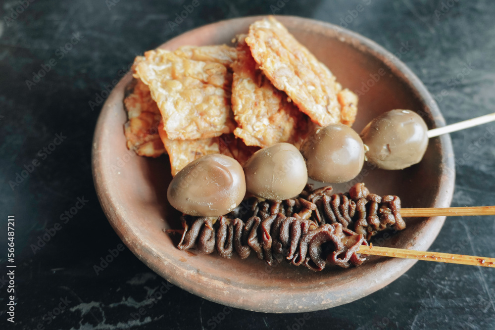 A photo of side dish contains of chicken intestine satay or sate usus ...