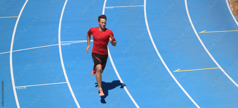 Runner athlete running on blue lanes track and field sport competition ...