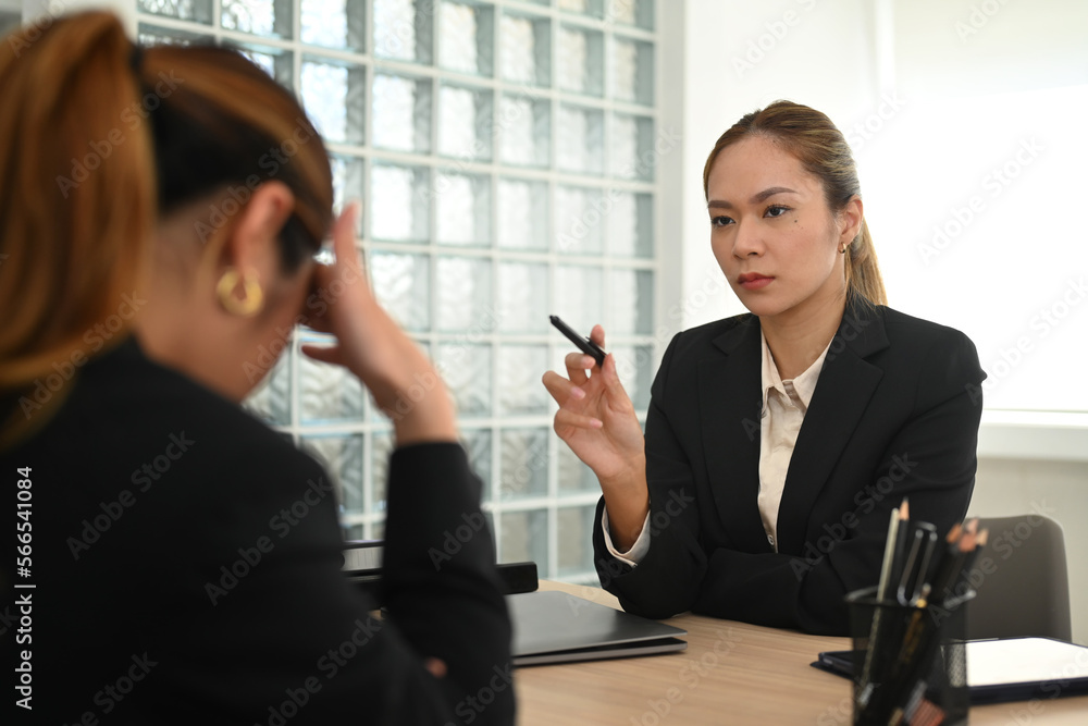 Furious female manager scolding young frustrated young employee with ...