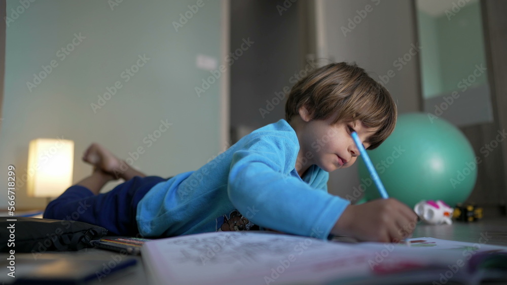 One Concentrated child doing school homework activity in bedroom ...