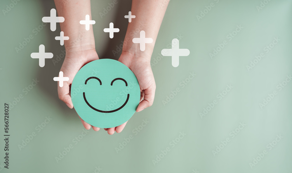 Hands holding green happy smile face, good feedback rating, positive ...