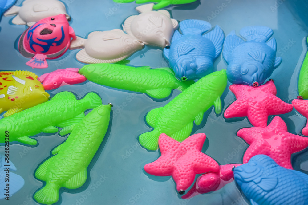 Fishing in the paddling pool. Children's toys in the pool. Toy fish ...
