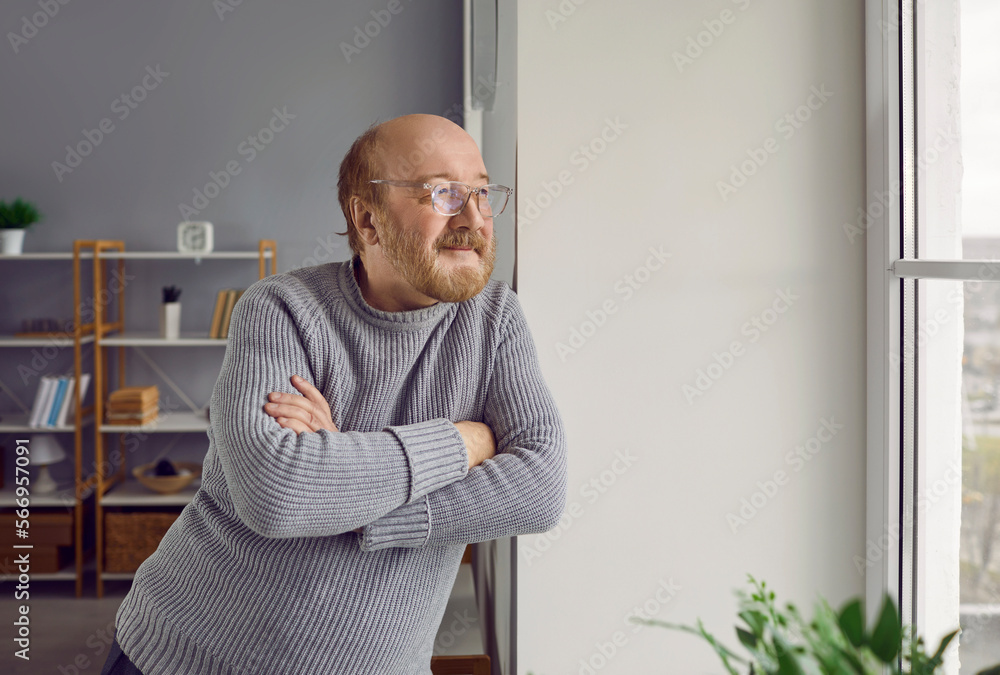 Happy retired senior man looking out the window. Portrait of a bald ...
