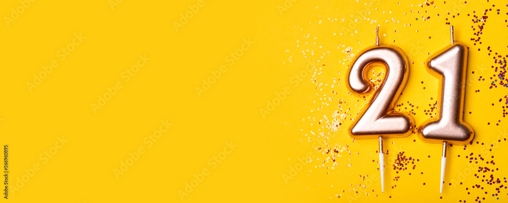 Gold candles in the form of number twenty one on yellow background with ...