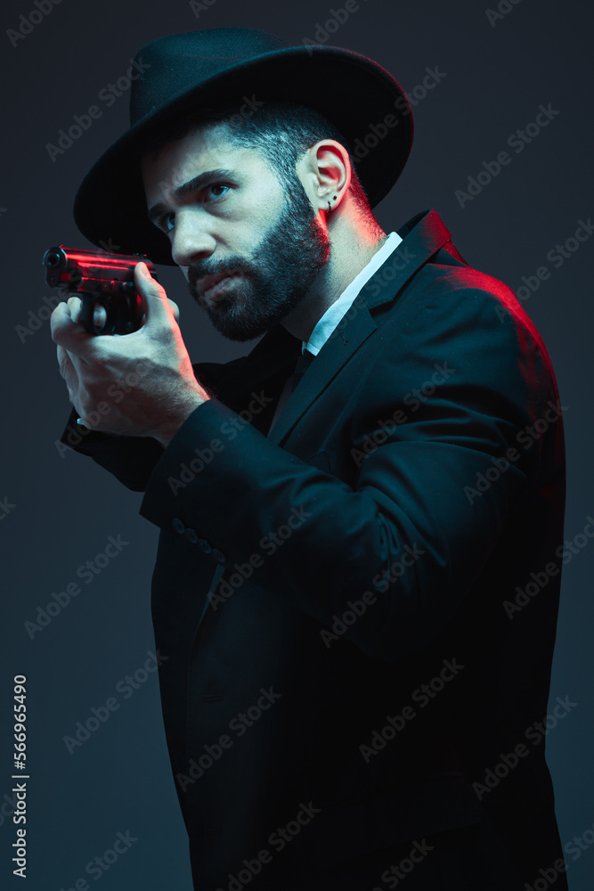 Foto de Gangster, suit and shooting gun on dark studio background in ...