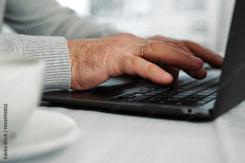 Closeup of senior man hands using laptop. Cropped side view of wrinkled ...