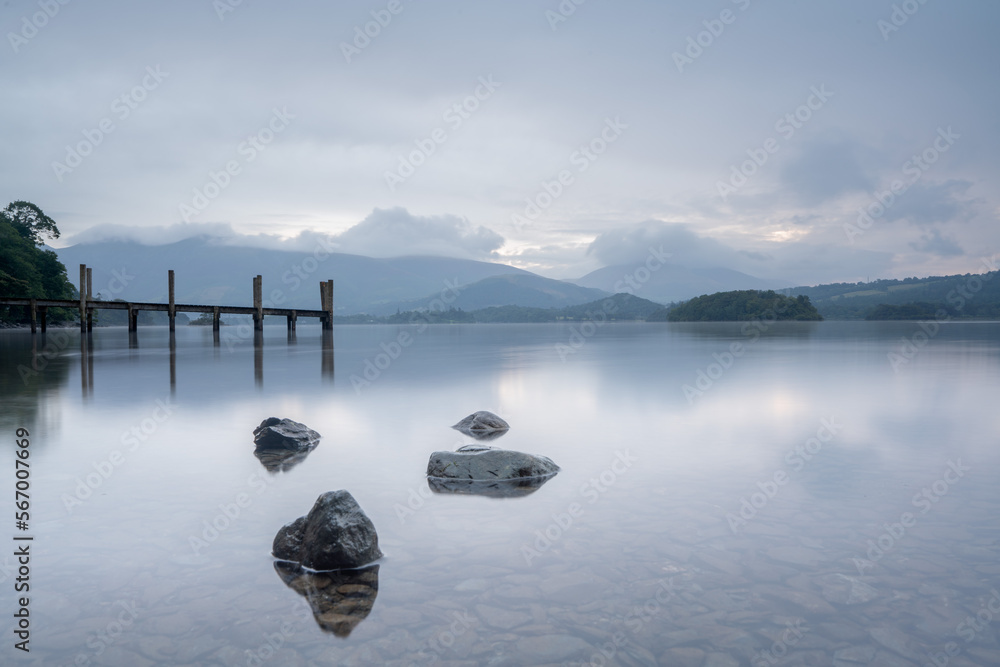 Derwentwater Jetty boat landing with wooden posts and long exposure to ...