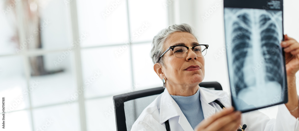 Poster Examining an x-ray image, female radiologist making a diagnosis ...