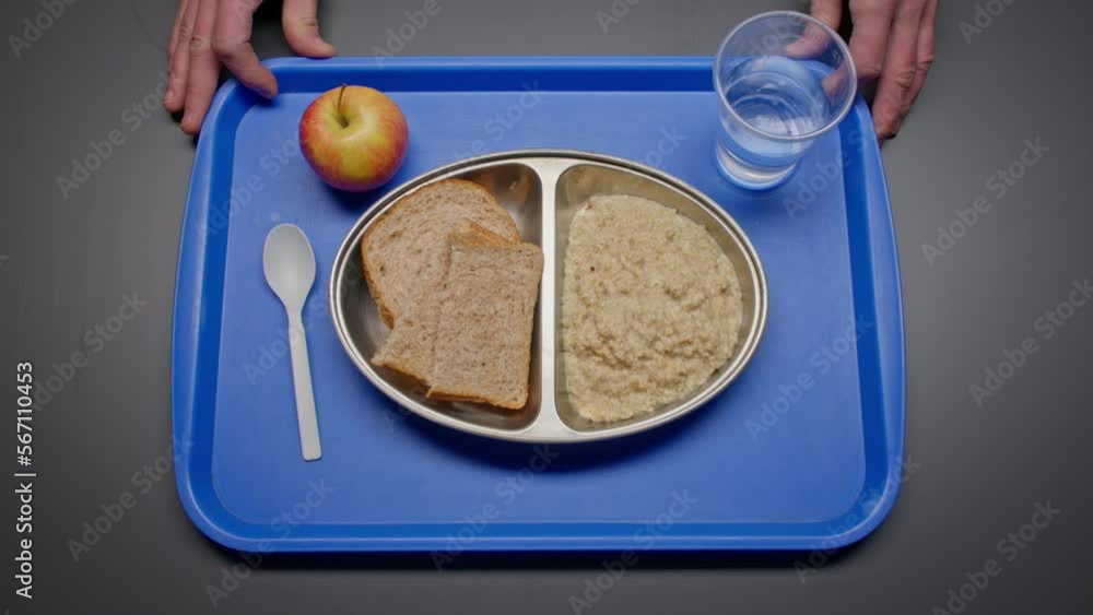 Basic meal of oatmeal, wholemeal bread, and water is served on a plain ...