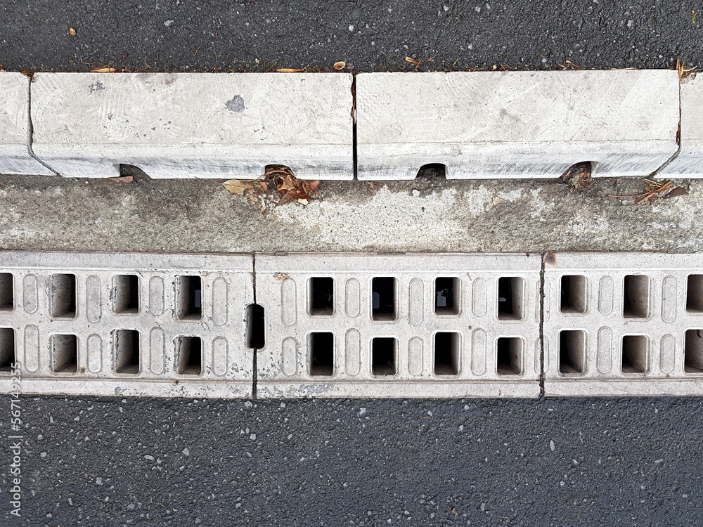 concrete grating drainage of an asphalt road with a curb, rainwater ...