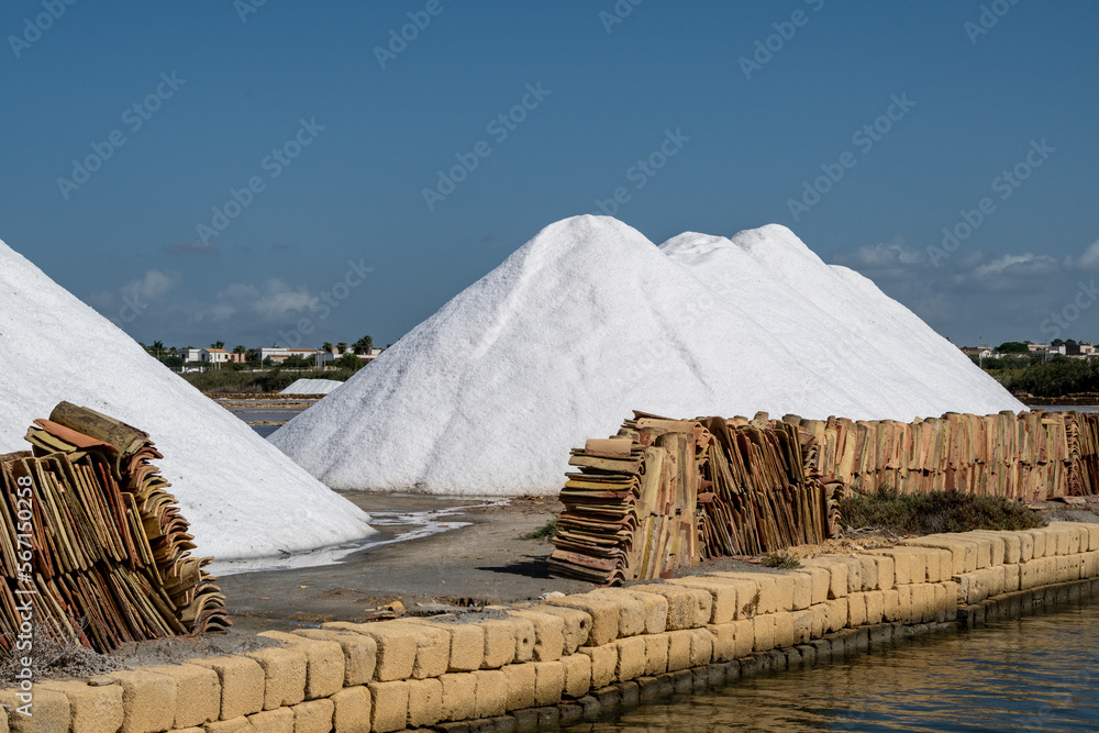 Pile of salt dry in the sun along a canal of the salt pans of the ...