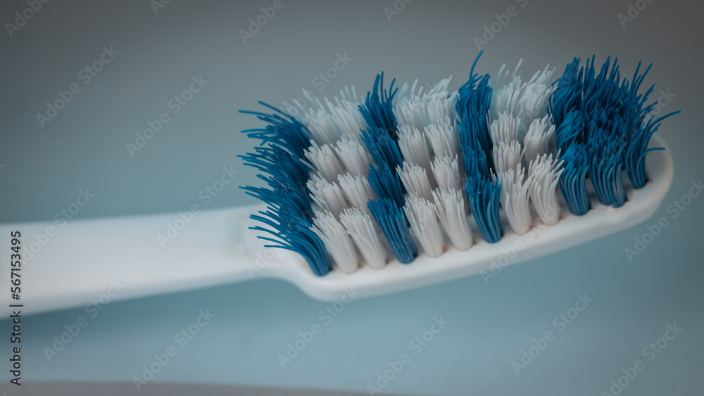 Macro close up photo of a worn white and blue toothbrush bristles ...