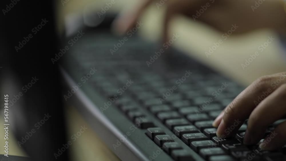 A office woman's hand is typing on a black computer keyboard provided ...
