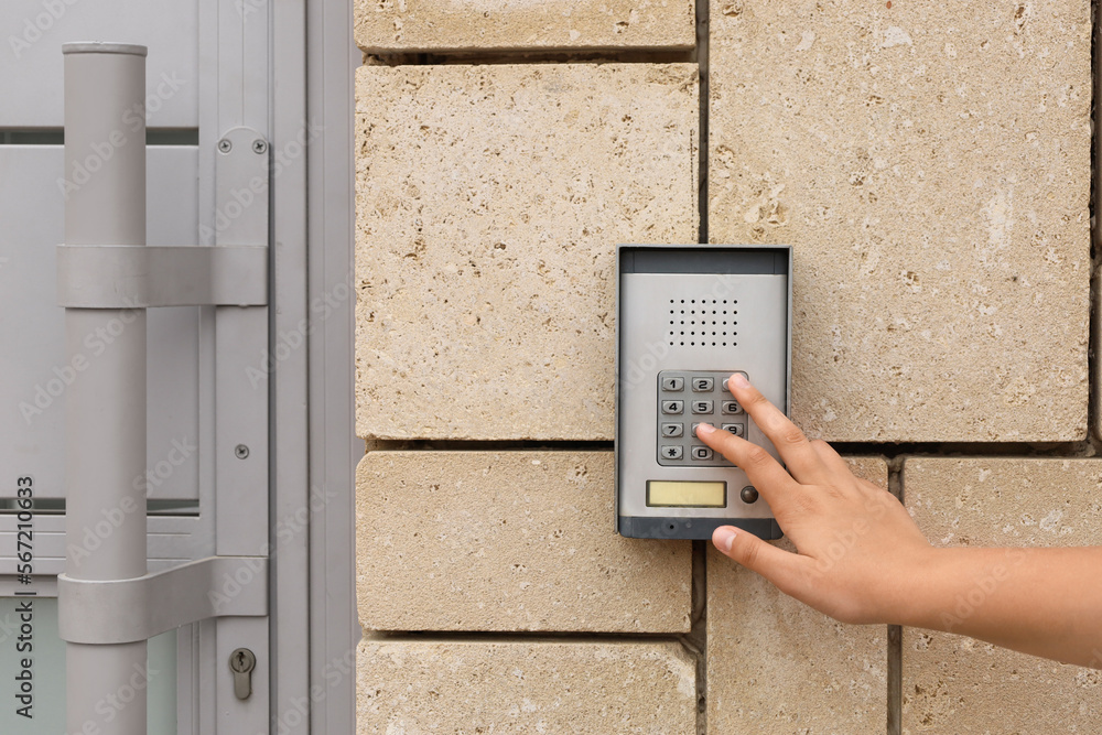 Child using modern intercom on stone wall outdoors, closeup Stock Photo ...