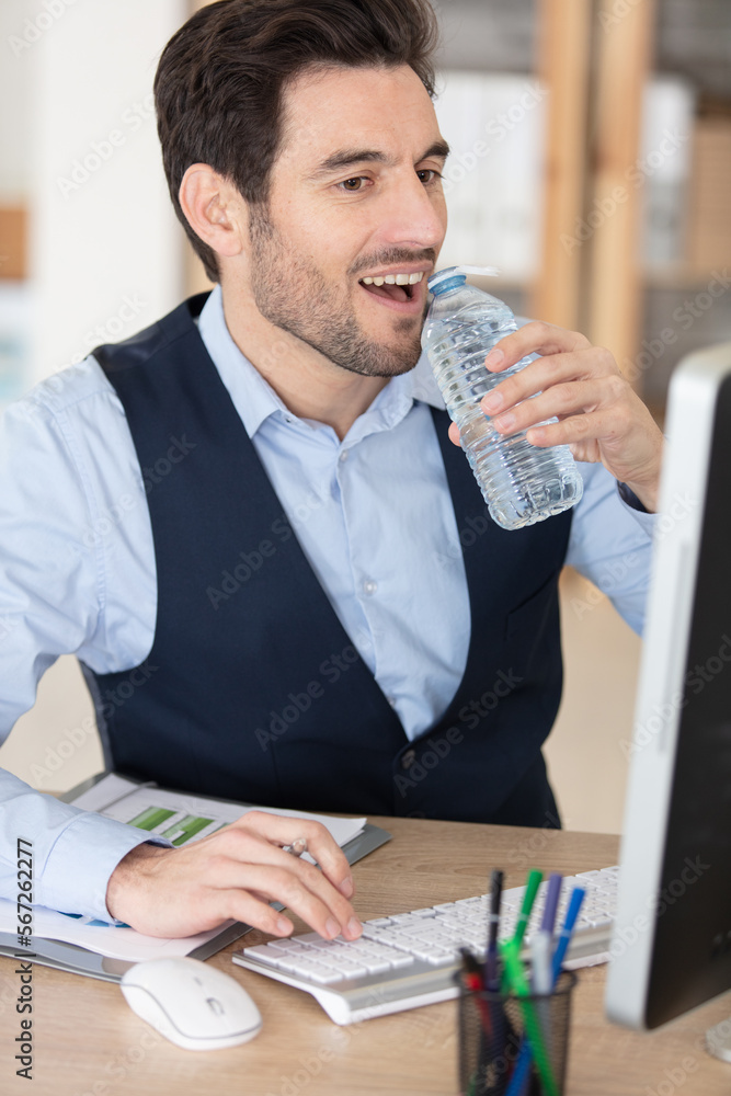 office worker drinking water in front of desktop computer Stock Photo ...