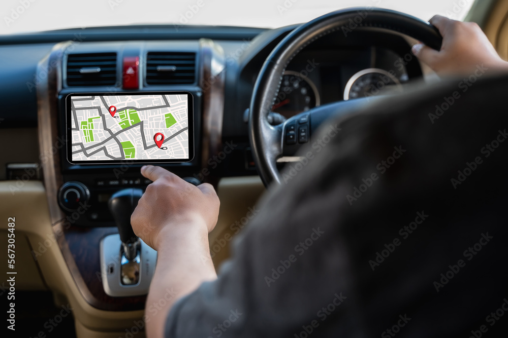 A man makes use of GPS and the internet. online map in the car controls ...