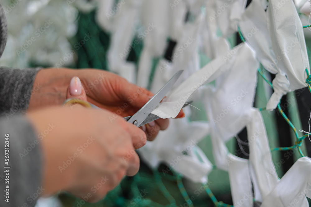 female hands weaving camouflage net for soldiers, war theme and ...