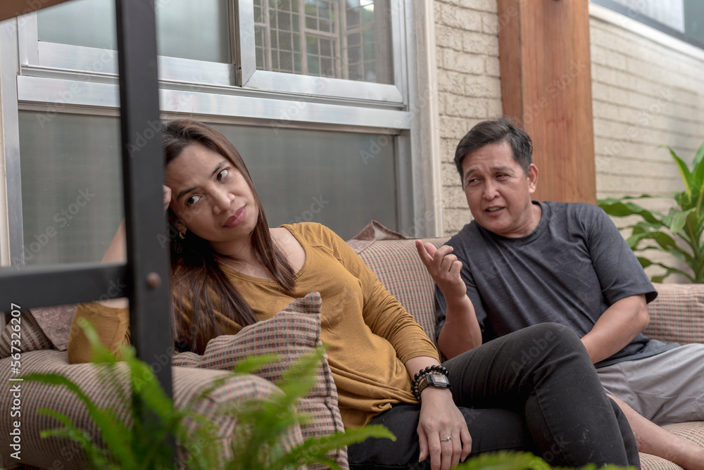 An asian woman is annoyed at her patronizing husband lecturing her on ...