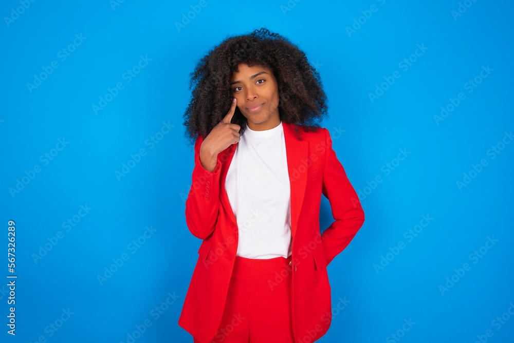 young businesswoman with afro hairstyle wearing red over blue ...
