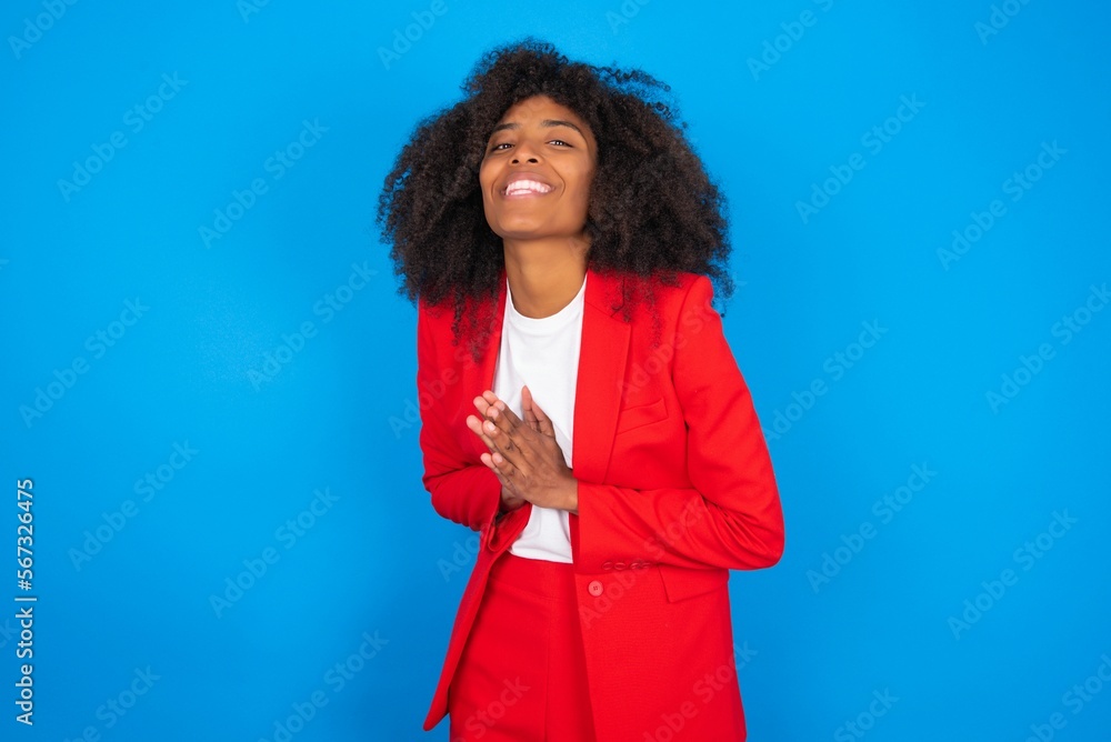 young businesswoman with afro hairstyle wearing red over blue ...