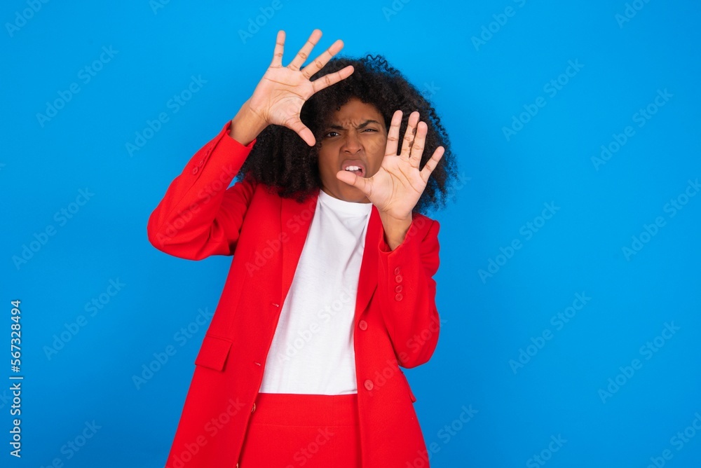 Dissatisfied young businesswoman with afro hairstyle wearing red over ...