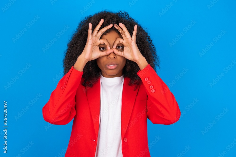 Playful excited young businesswoman with afro hairstyle wearing red ...