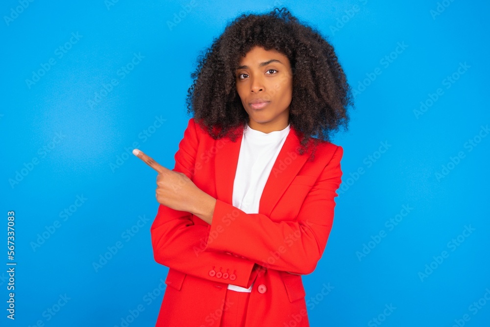 young businesswoman with afro hairstyle wearing red over blue ...