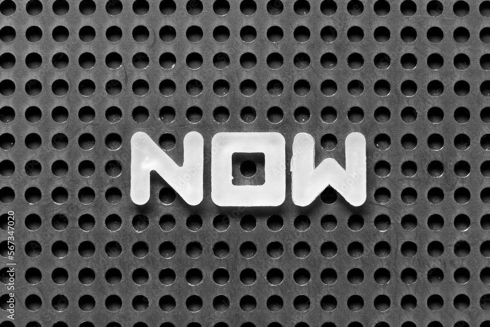 White alphabet letter in word now on black pegboard background Stock ...