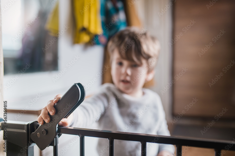 Foto Stock Toddler tries open lock on child safety gate. The child ...