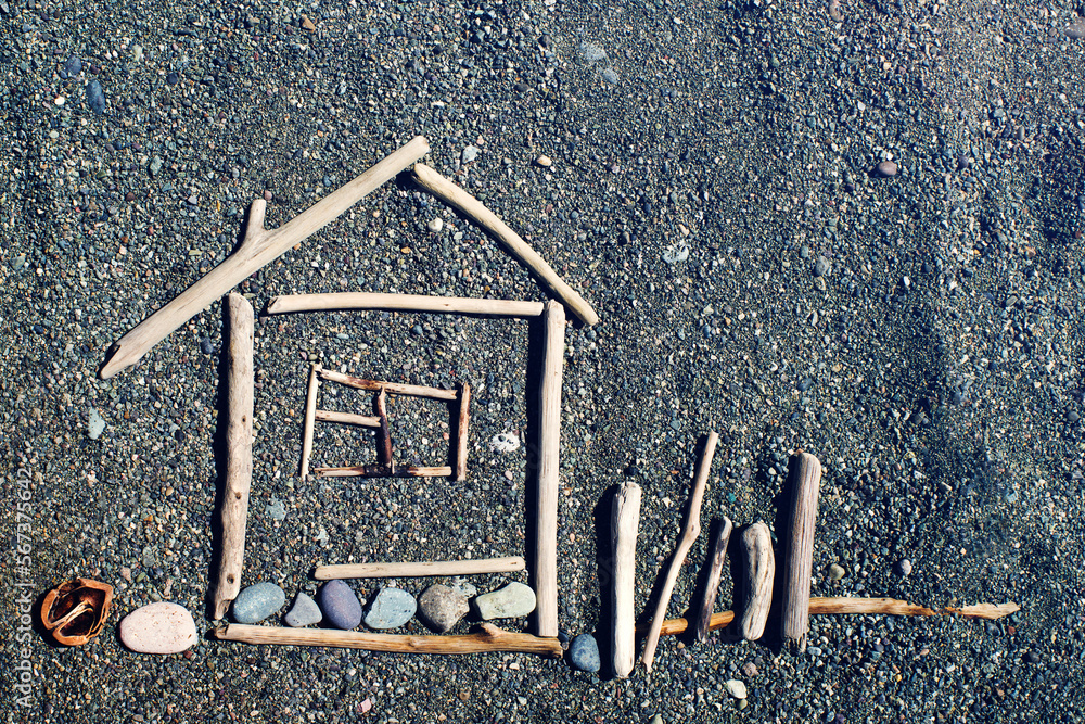 Foto de Image of a little house from wooden sticks on the sea pebble ...